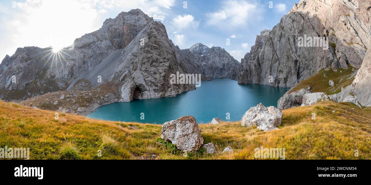 Mountain lake Kol Suu with rocky steep mountains, Sun Star, Kol Suu ...