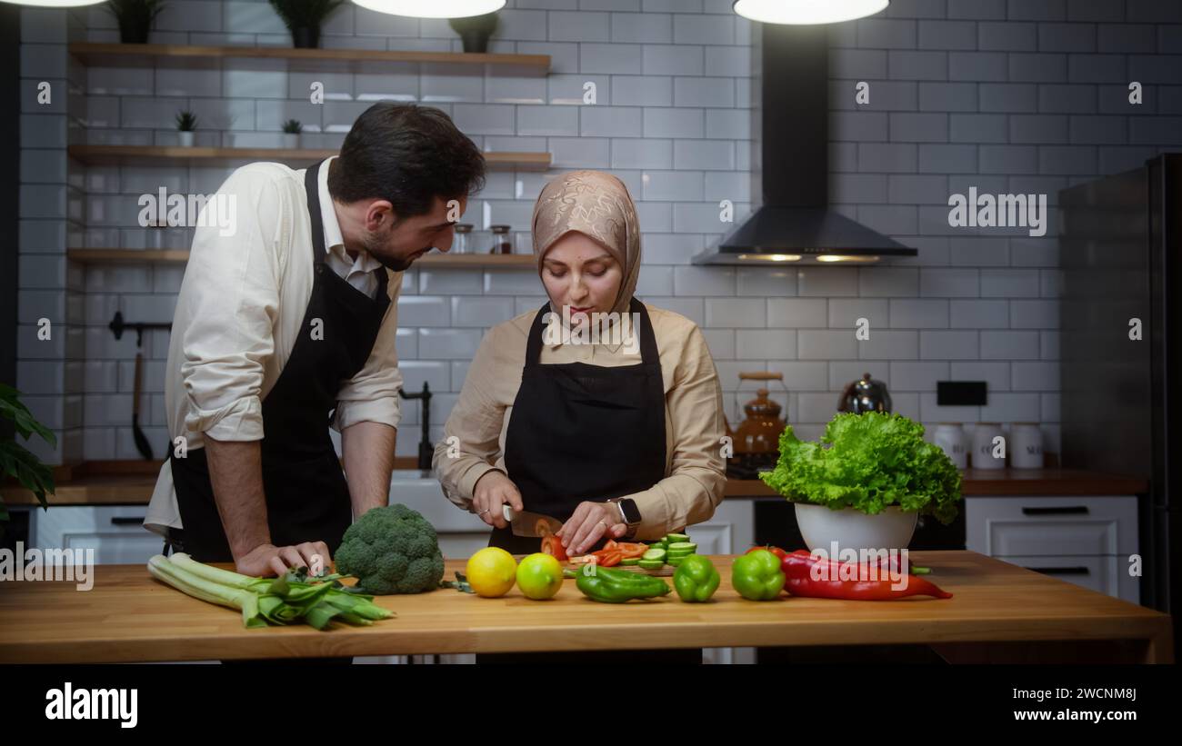 Young happy couple enjoy conversation in the modern kitchen and prepare ...
