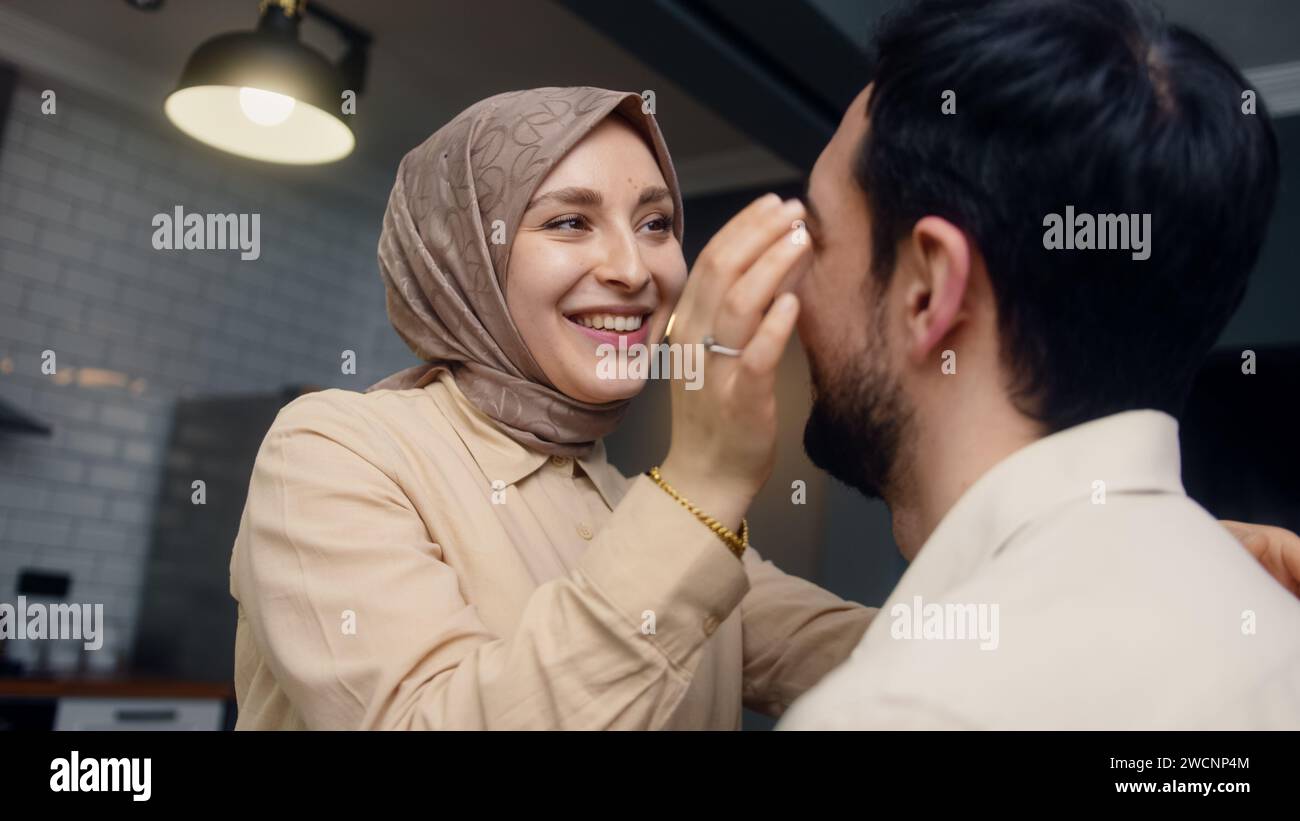 Happy married couple standing at home, the woman caresses her husband ...