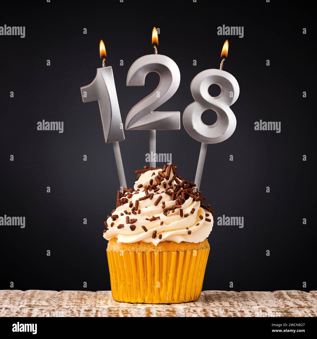 birthday cupcake with number 128 candle - Celebration on dark ...