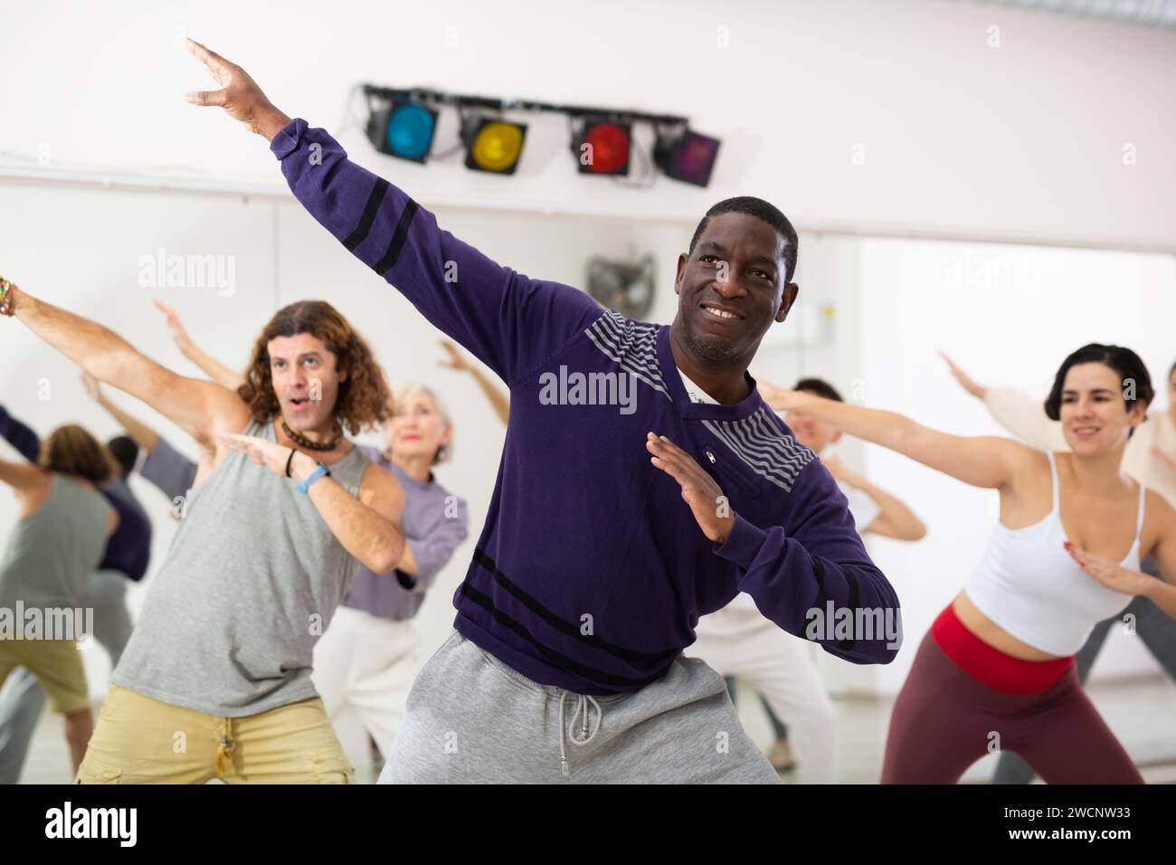 Happy african man learning new modern dance in group dance lesson Stock ...