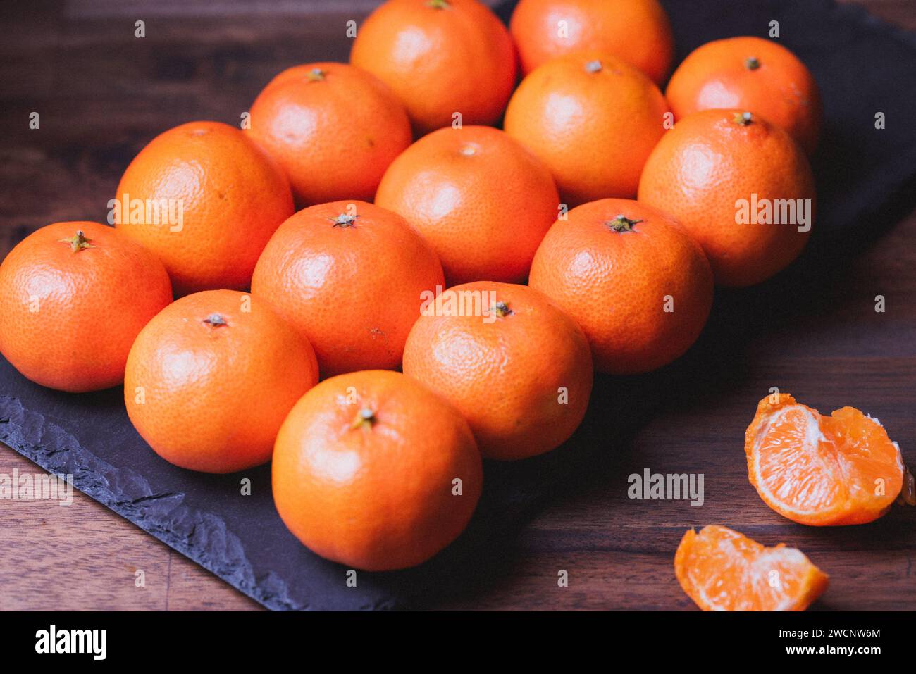 clementine fruit. Photo of tangerines lined up in rows on the black ...