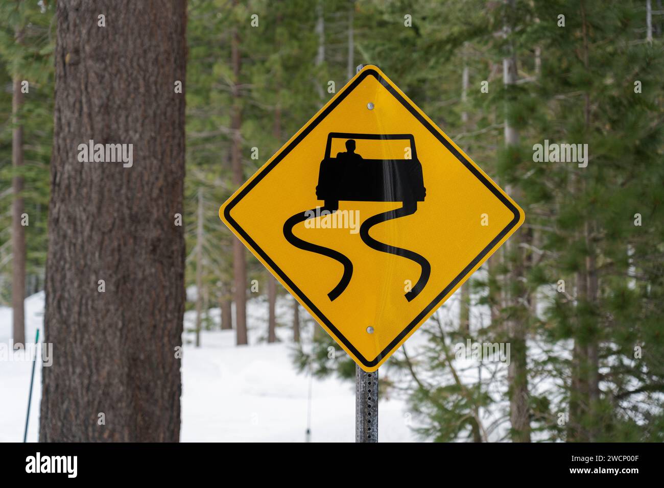 Slipper When Wet Road Sign with Snowy Winter Backdrop Stock Photo - Alamy