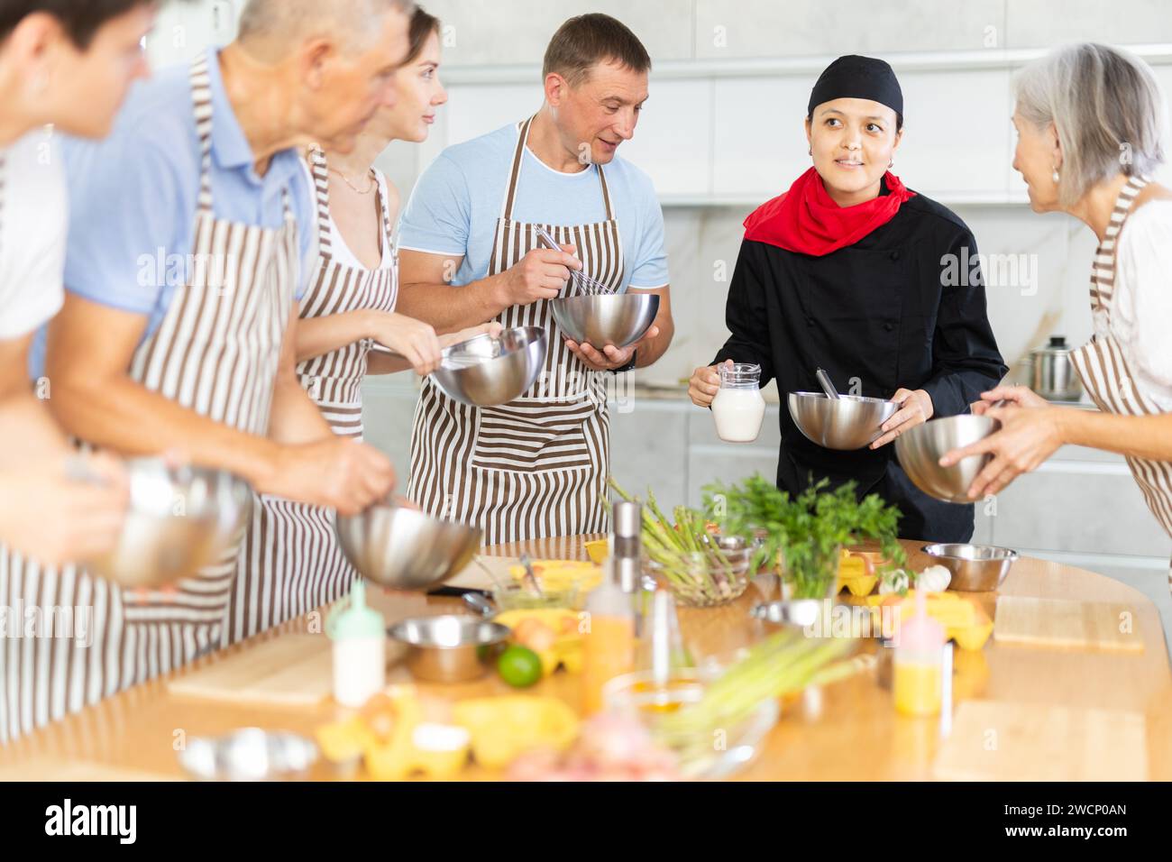 Group of people and female chef at cooking classes Stock Photo - Alamy