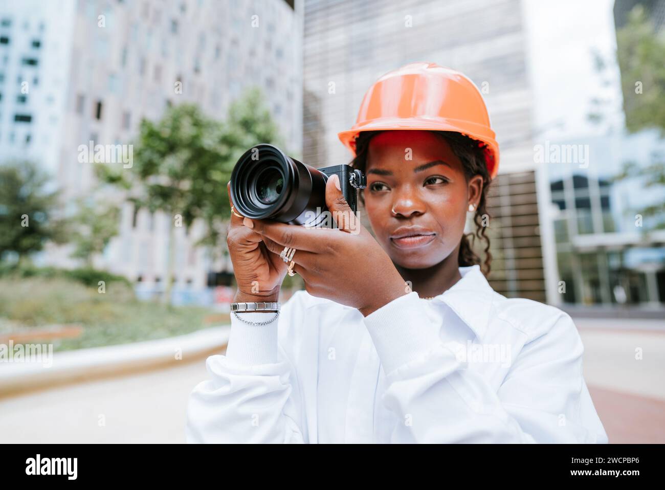 Serious black female photographer using camera on street Stock Photo ...