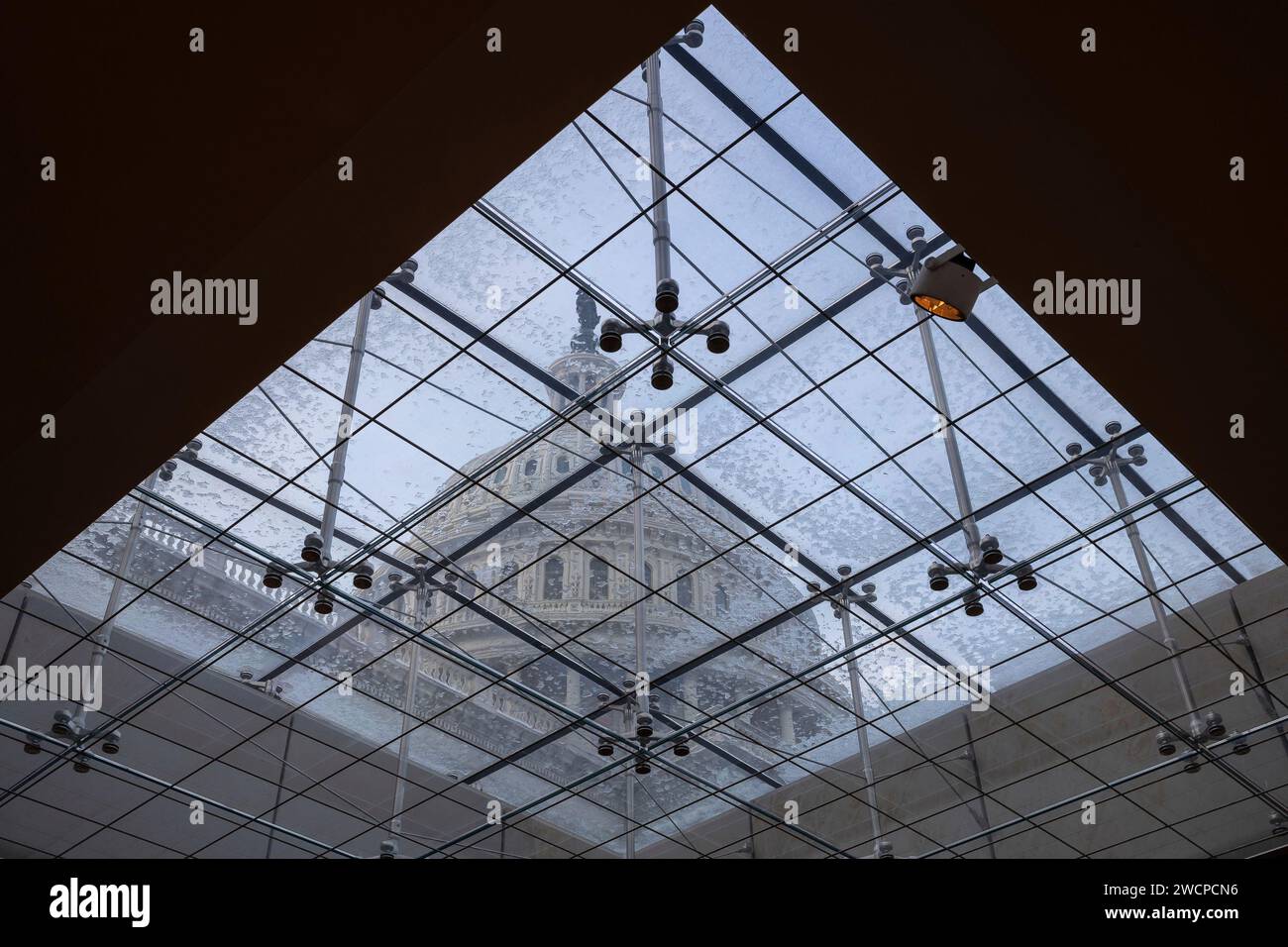 The dome of the U.S. Capitol building is seen through a frosty skylight ...