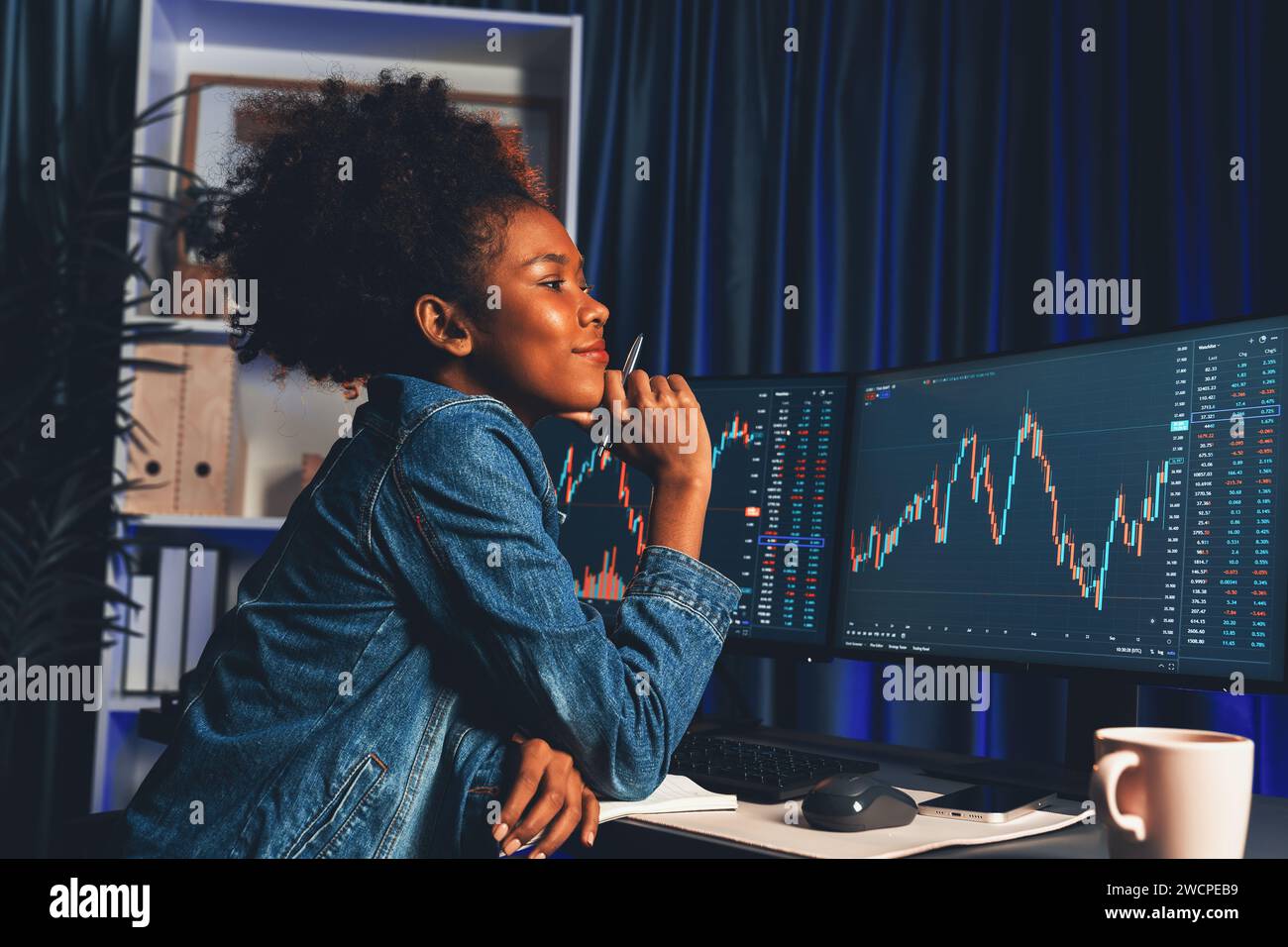 Young African woman trader smiling on happy face, looking on screen ...