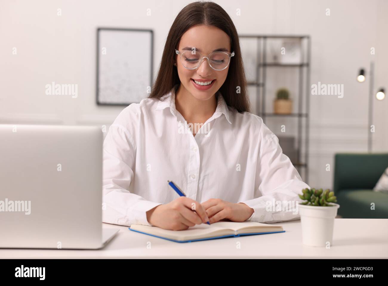 Woman writing in office planner hi-res stock photography and images - Alamy