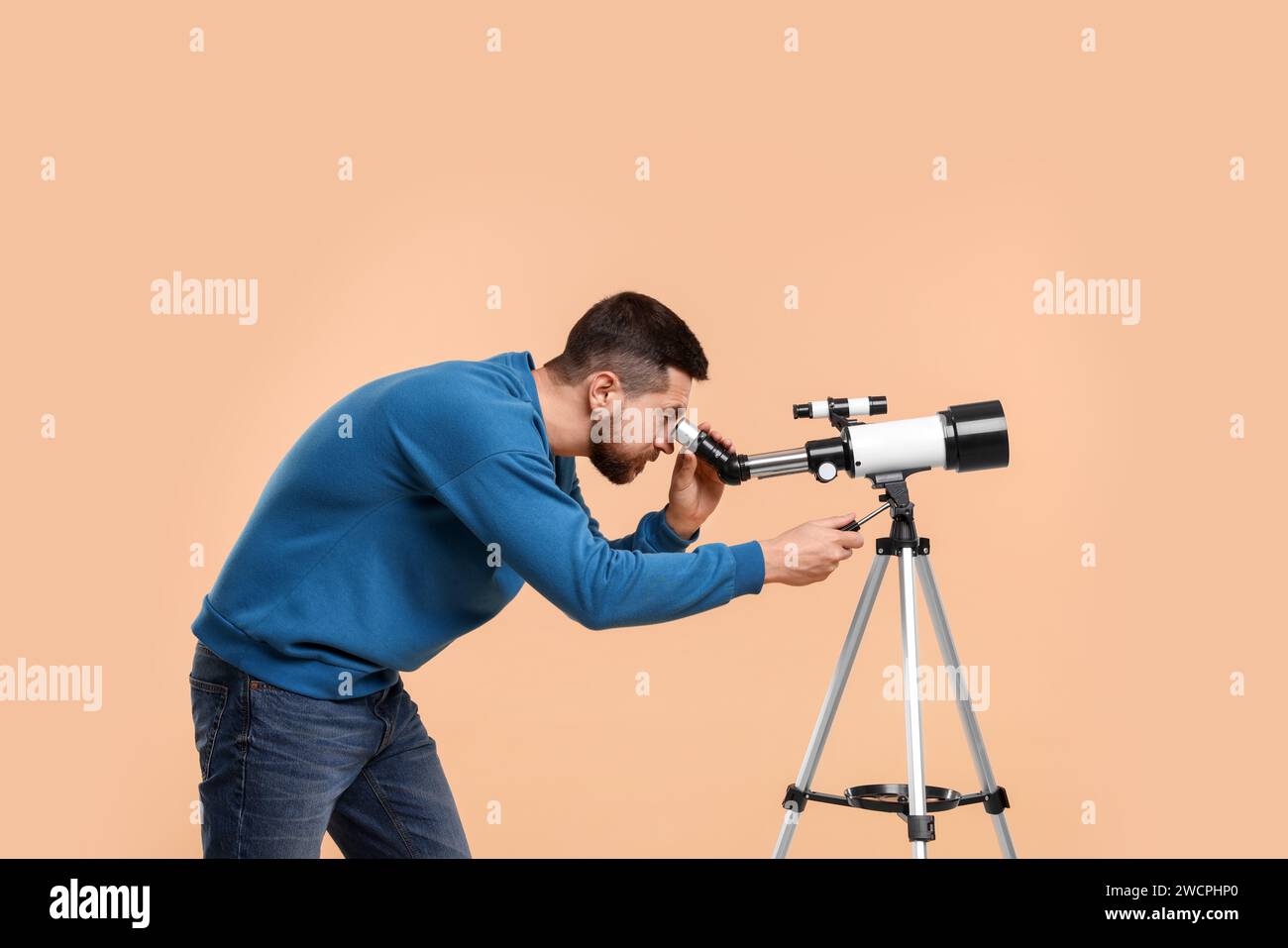 Astronomer looking at stars through telescope on beige background Stock ... Astronomer looking at stars through telescope on beige background Stock ...
