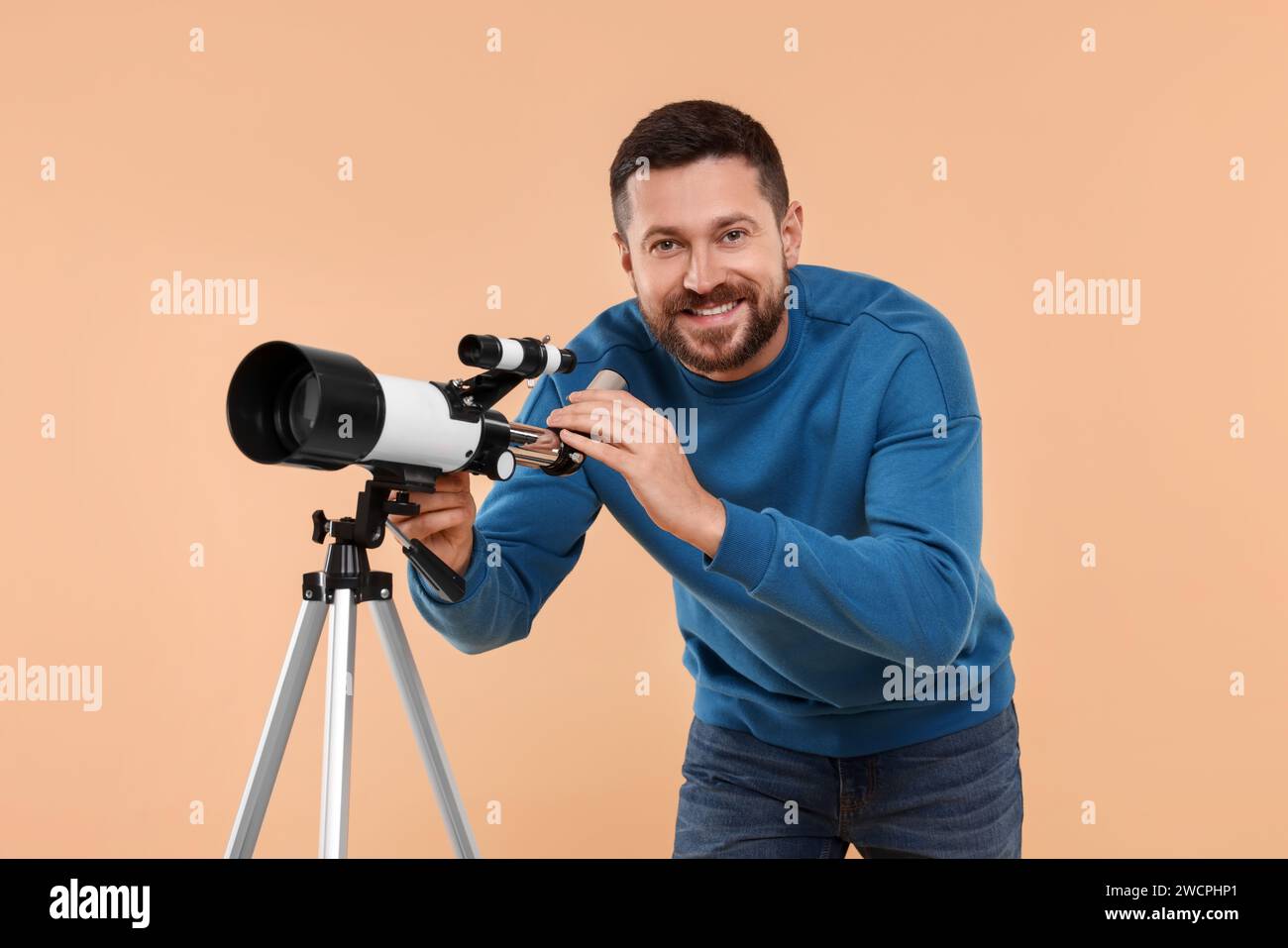 Happy astronomer with telescope on beige background Stock Photo - Alamy