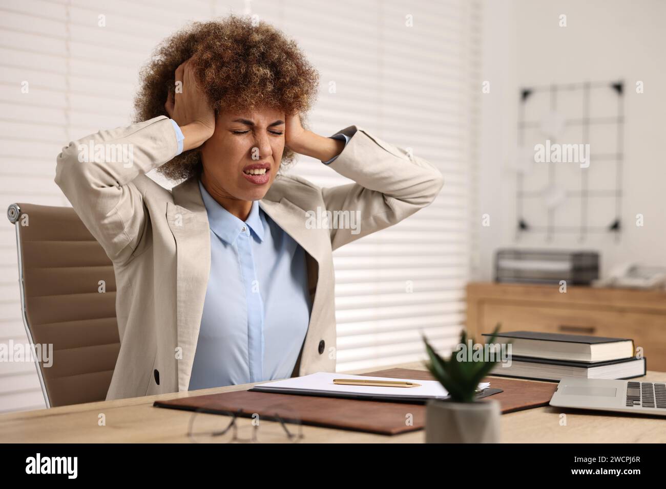 Woman suffering from headache at workplace in office Stock Photo - Alamy