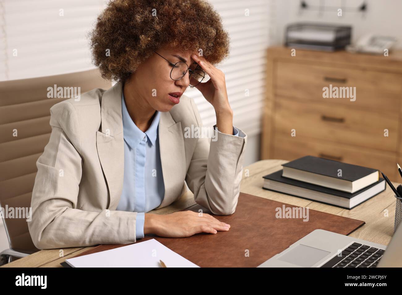 Woman suffering from headache at workplace in office Stock Photo - Alamy