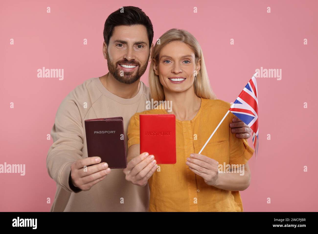 Immigration. Happy couple with passports and flag of United Kingdom on ...
