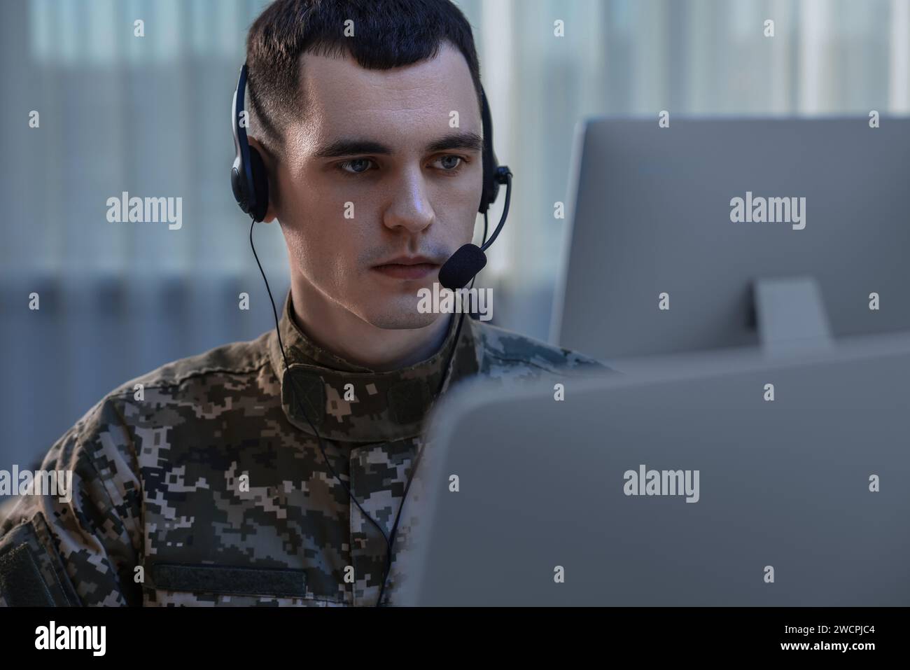 Military service. Young soldier in headphones working in office Stock ...