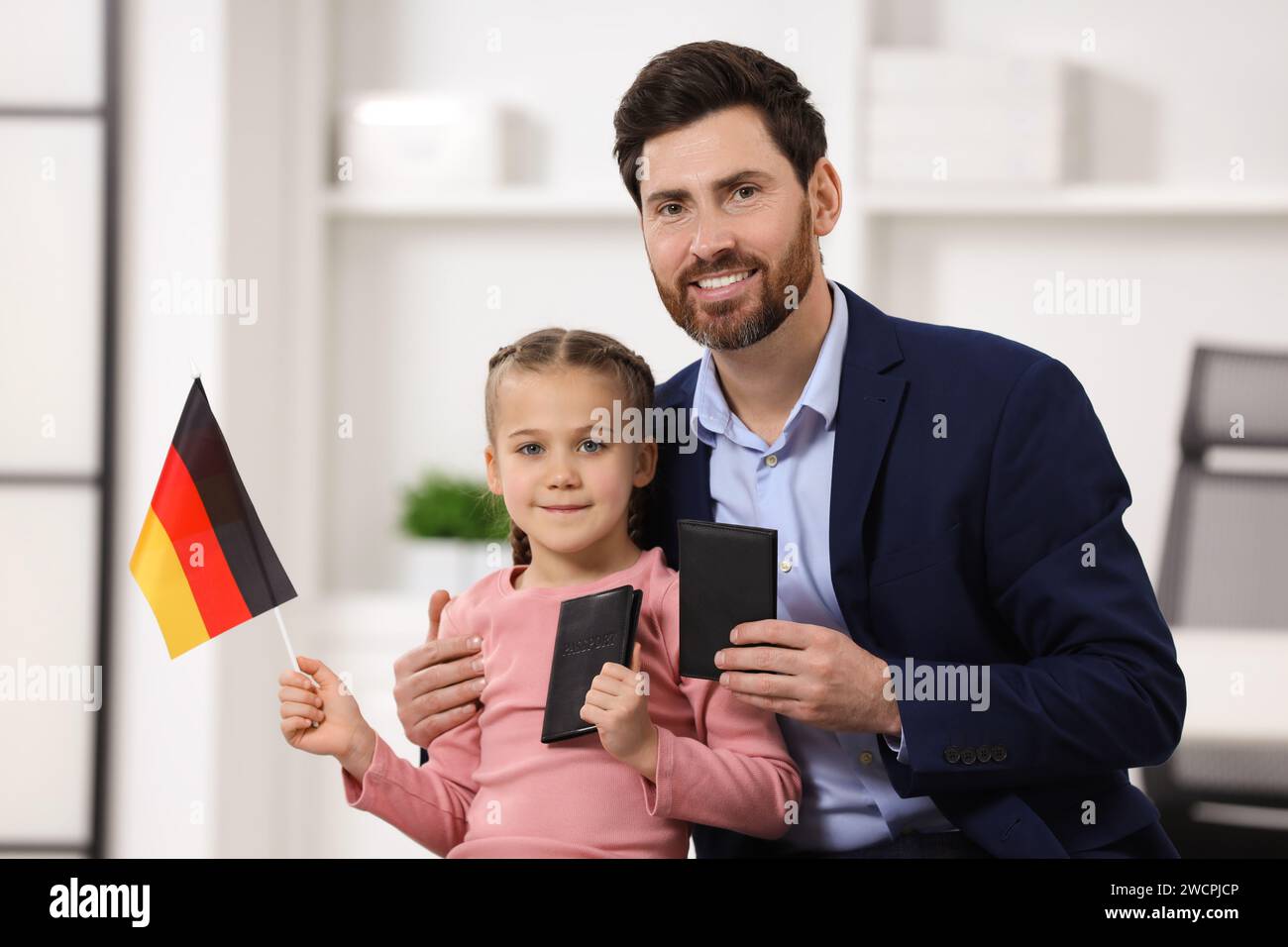 Immigration. Happy man with his daughter holding passports and flag of ...
