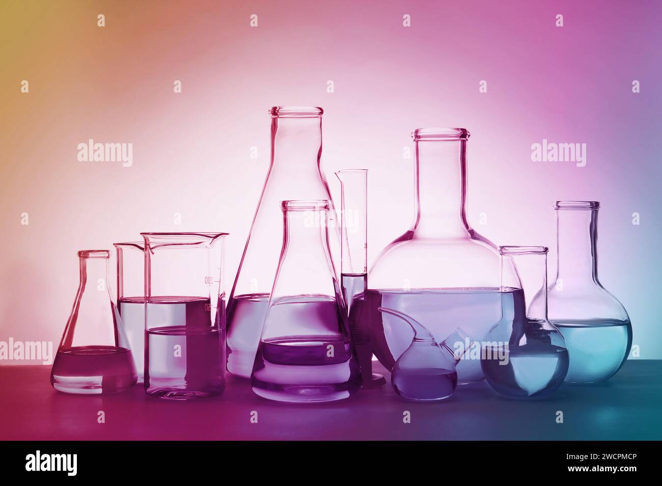 Laboratory glassware with liquid on table. Color toned Stock Photo - Alamy