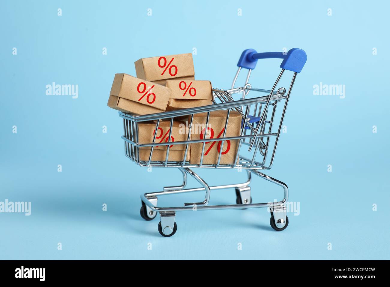Discount offer. Boxes with percent signs in mini shopping cart on light ...