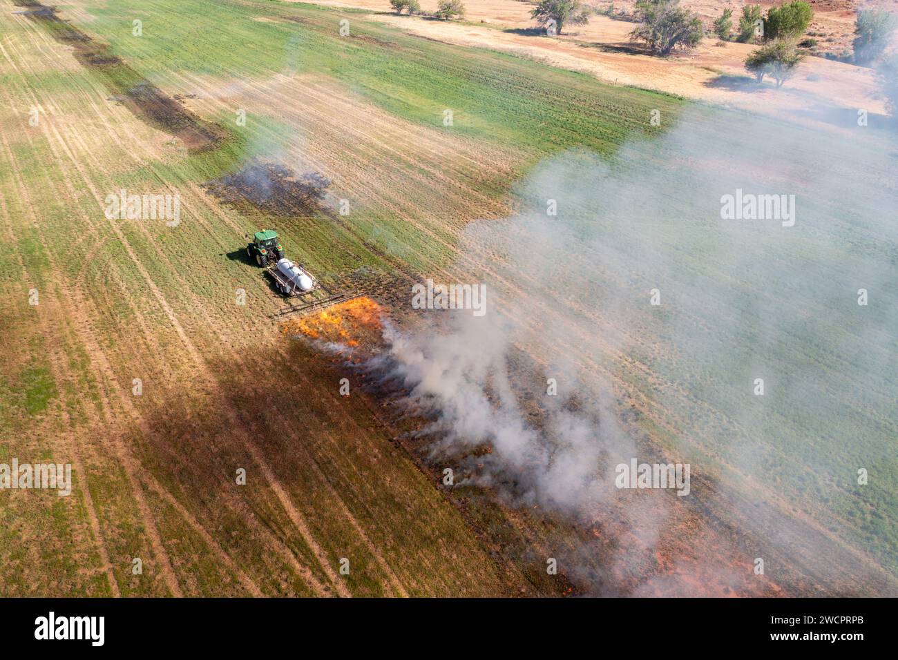 Aerial view of tractor pulling propane burner in hay field Stock Photo ...