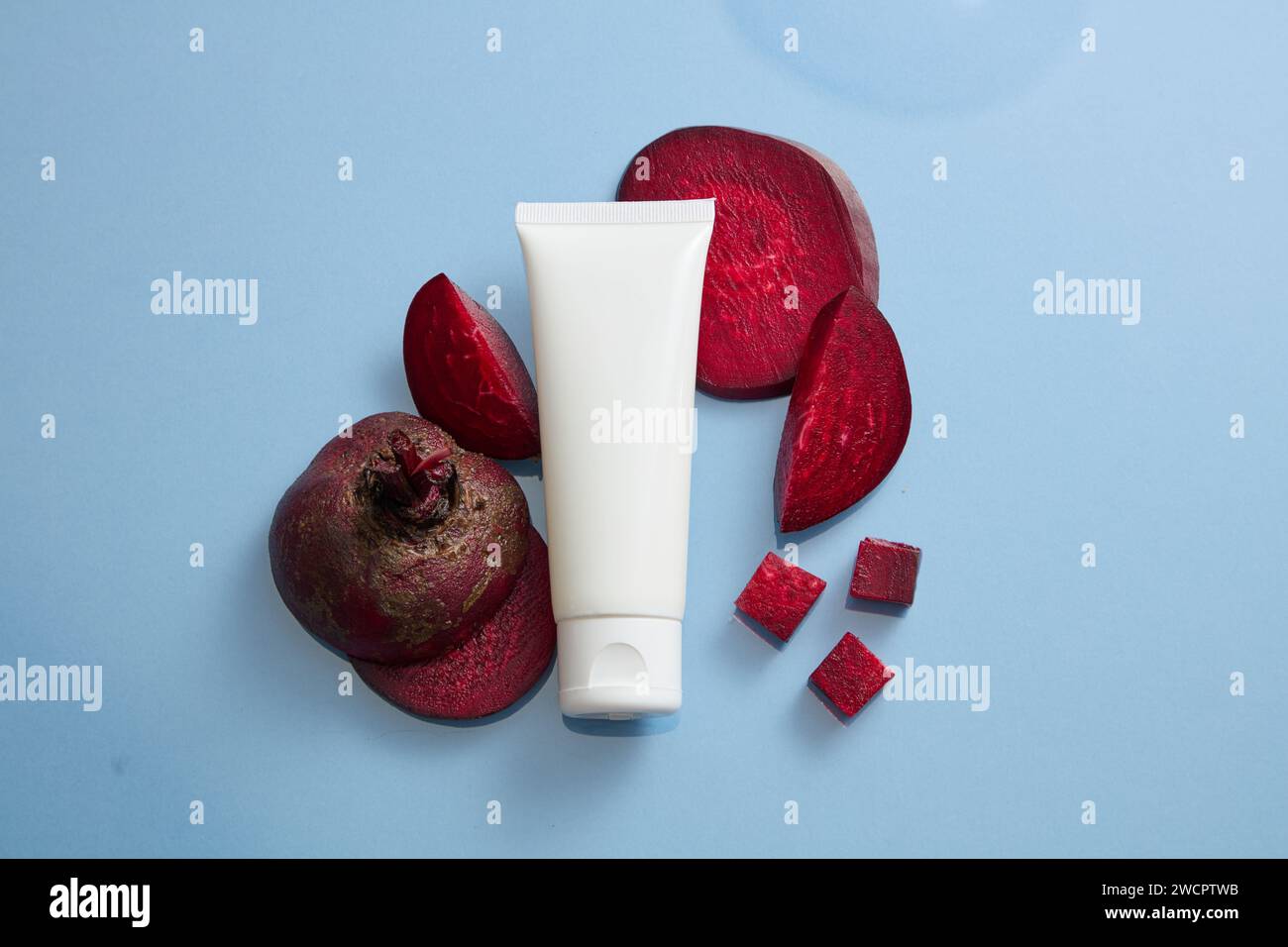Unbranded tube in white color is displayed with fresh beetroot on blue ...
