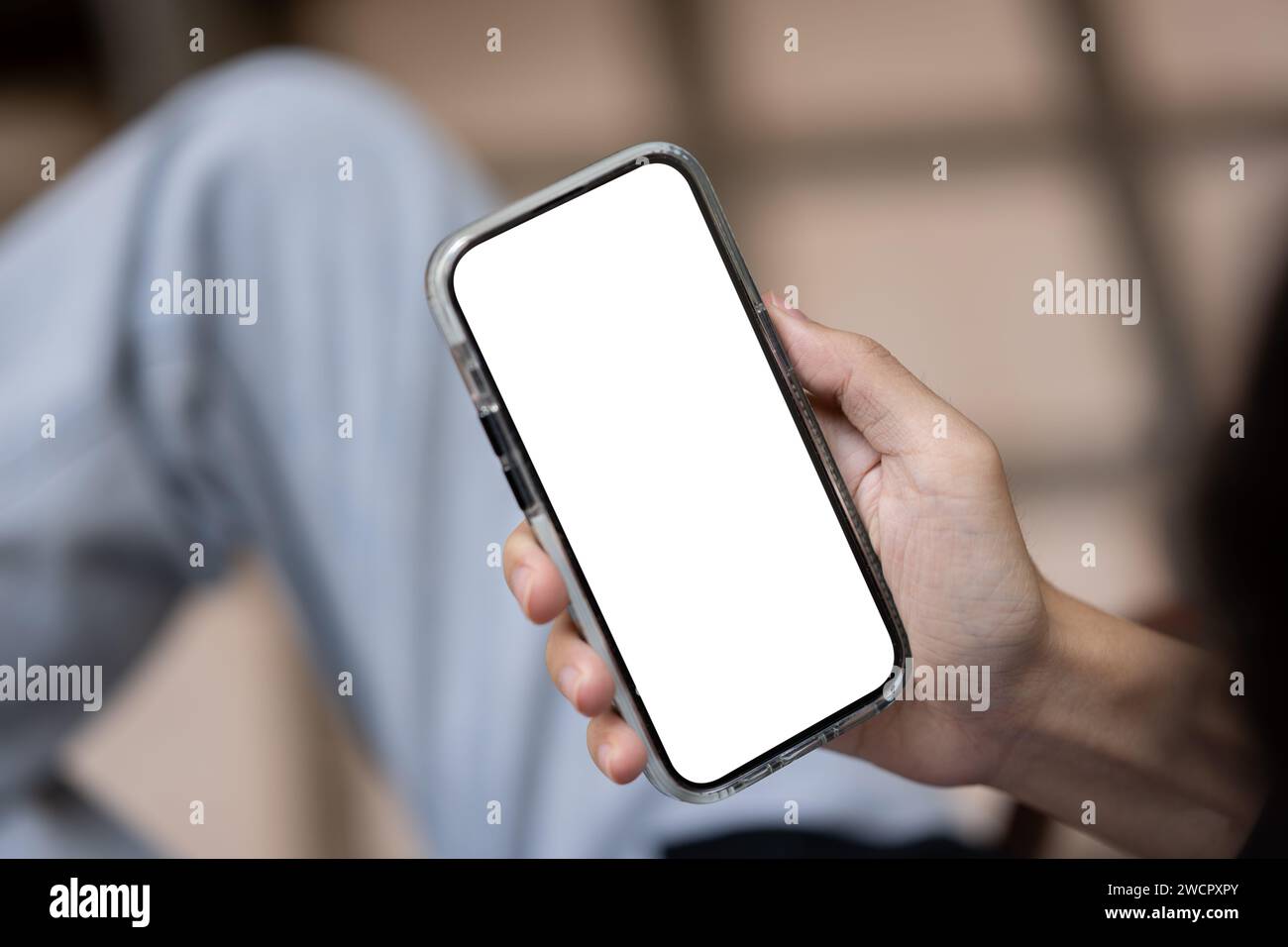 Close-up image of a man using his smartphone while sitting outdoors. a ...