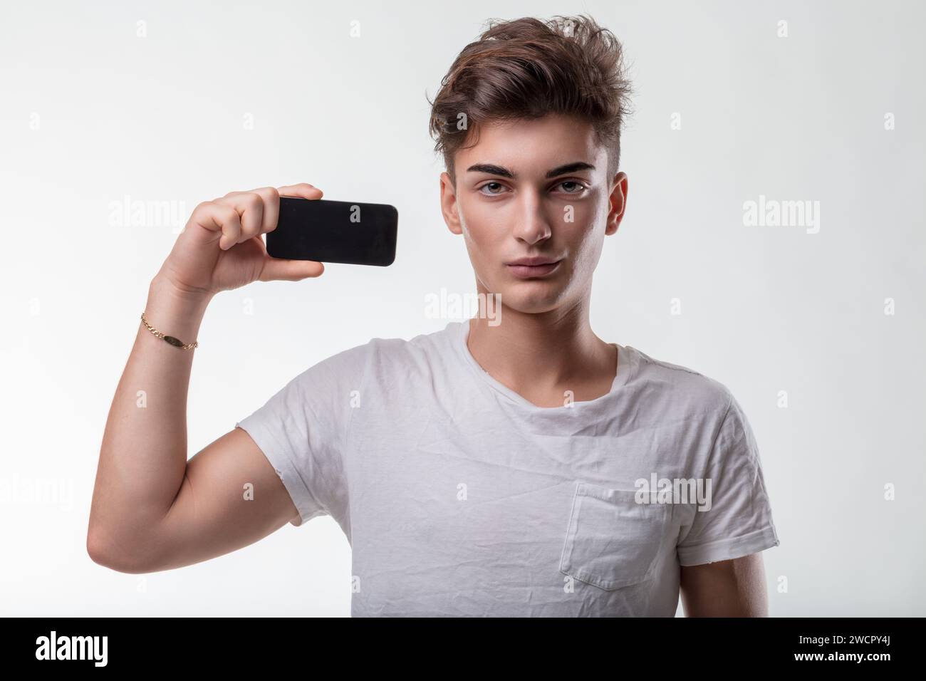 Hidden gaze behind a smartphone, the man's confident air is punctuated ...