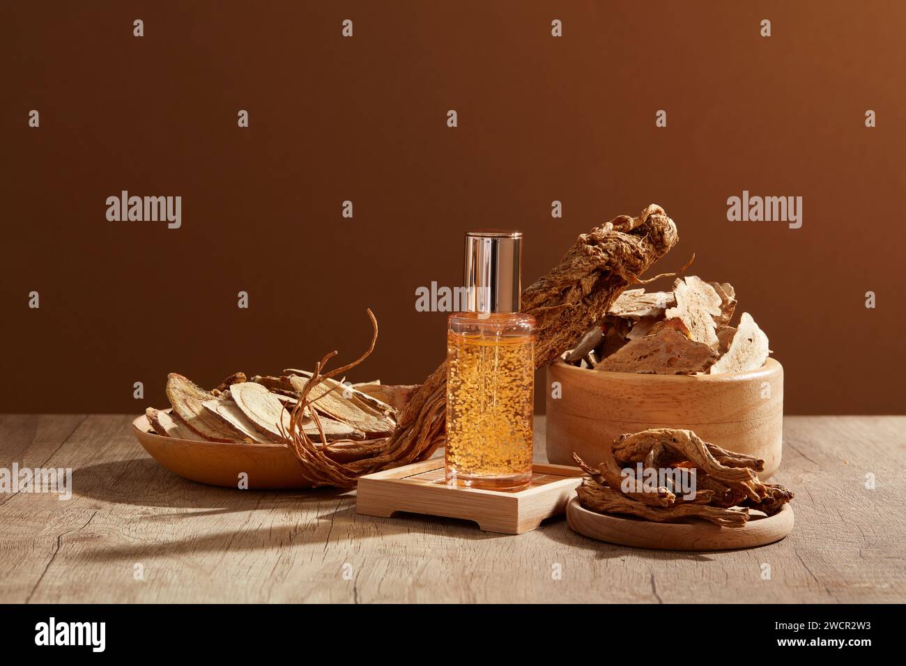 A serum glass bottle filled with yellow essence standing on a podium ...