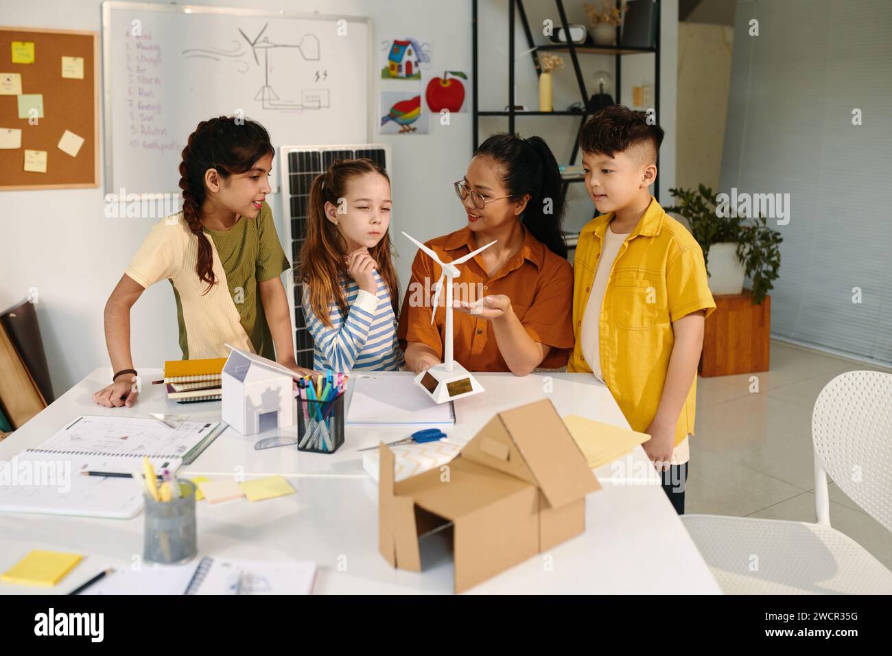 Children working around table hi-res stock photography and images - Alamy
