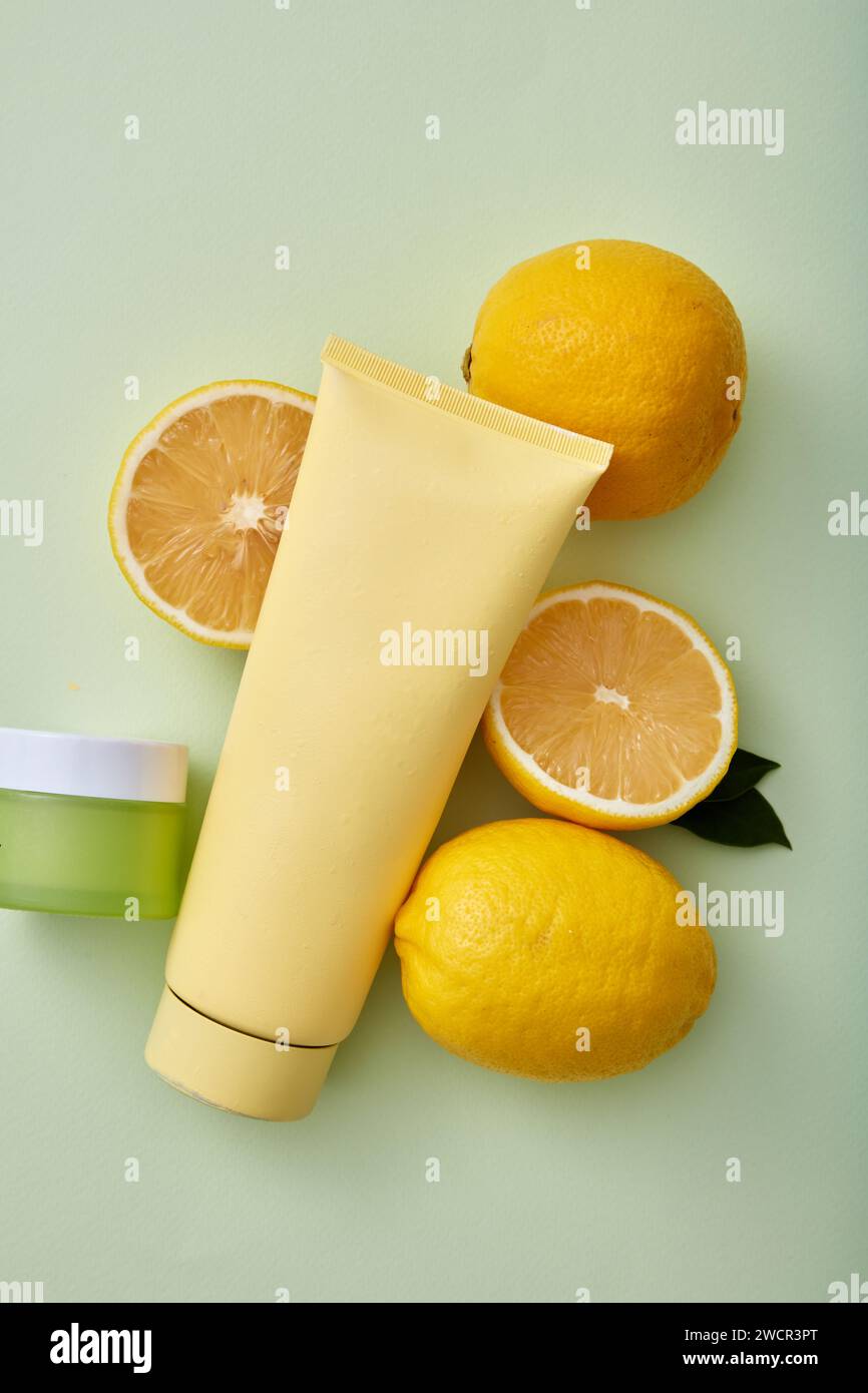 Beauty tube decorated with several lemon cut in halves against pastel ...
