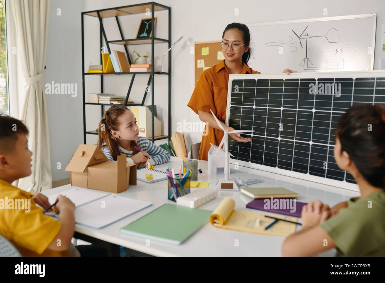 Teacher explaining group of kids how solar panel works Stock Photo - Alamy