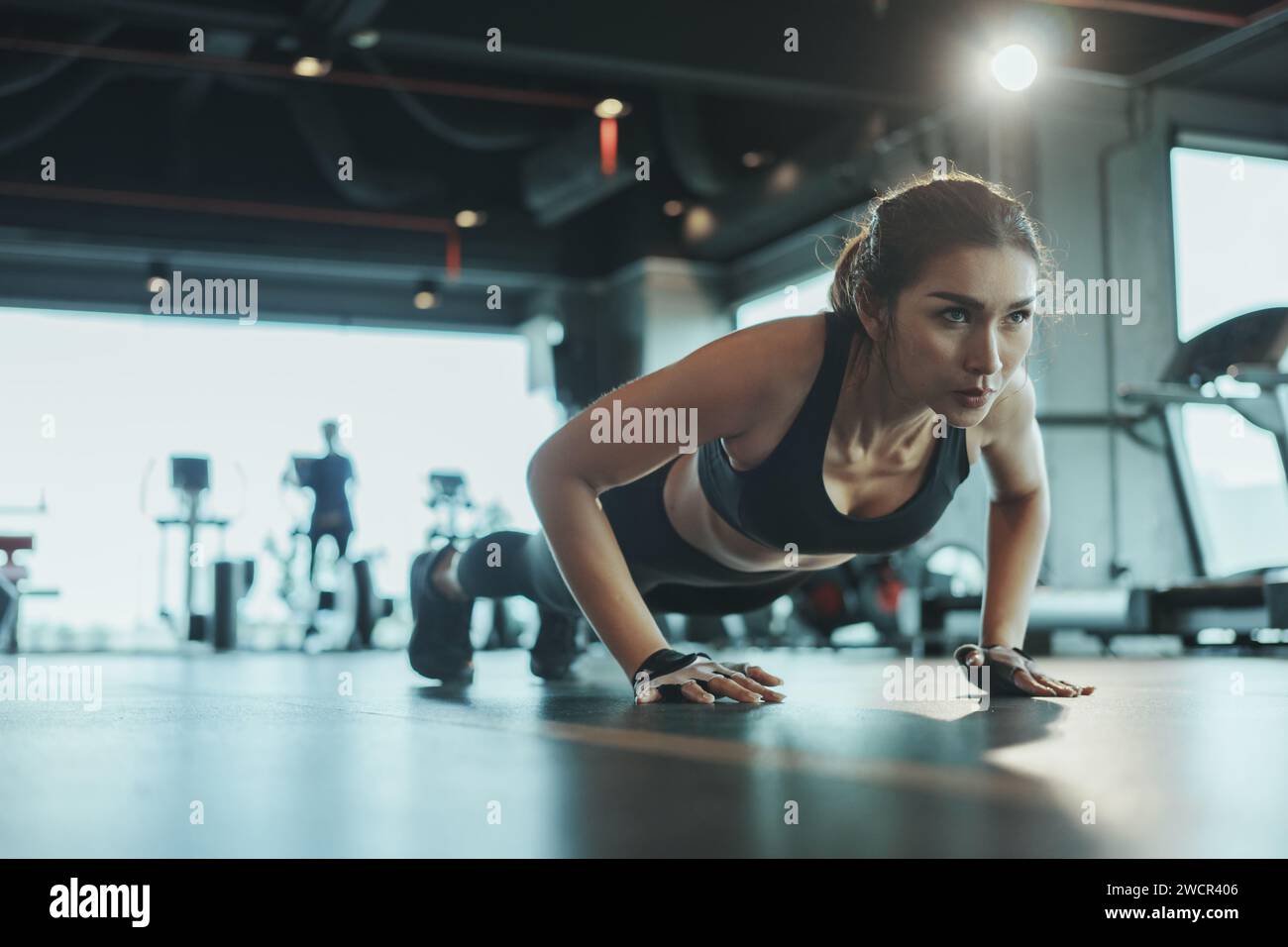 Sporty woman performing push-ups from the floor in the gym Stock Photo ...