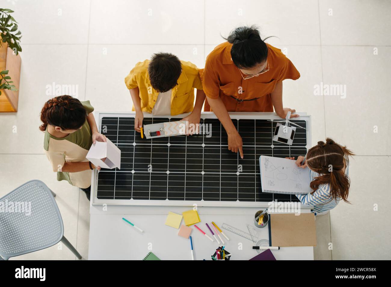 Teacher and schoolkids discussing solar energy and sustainability ...