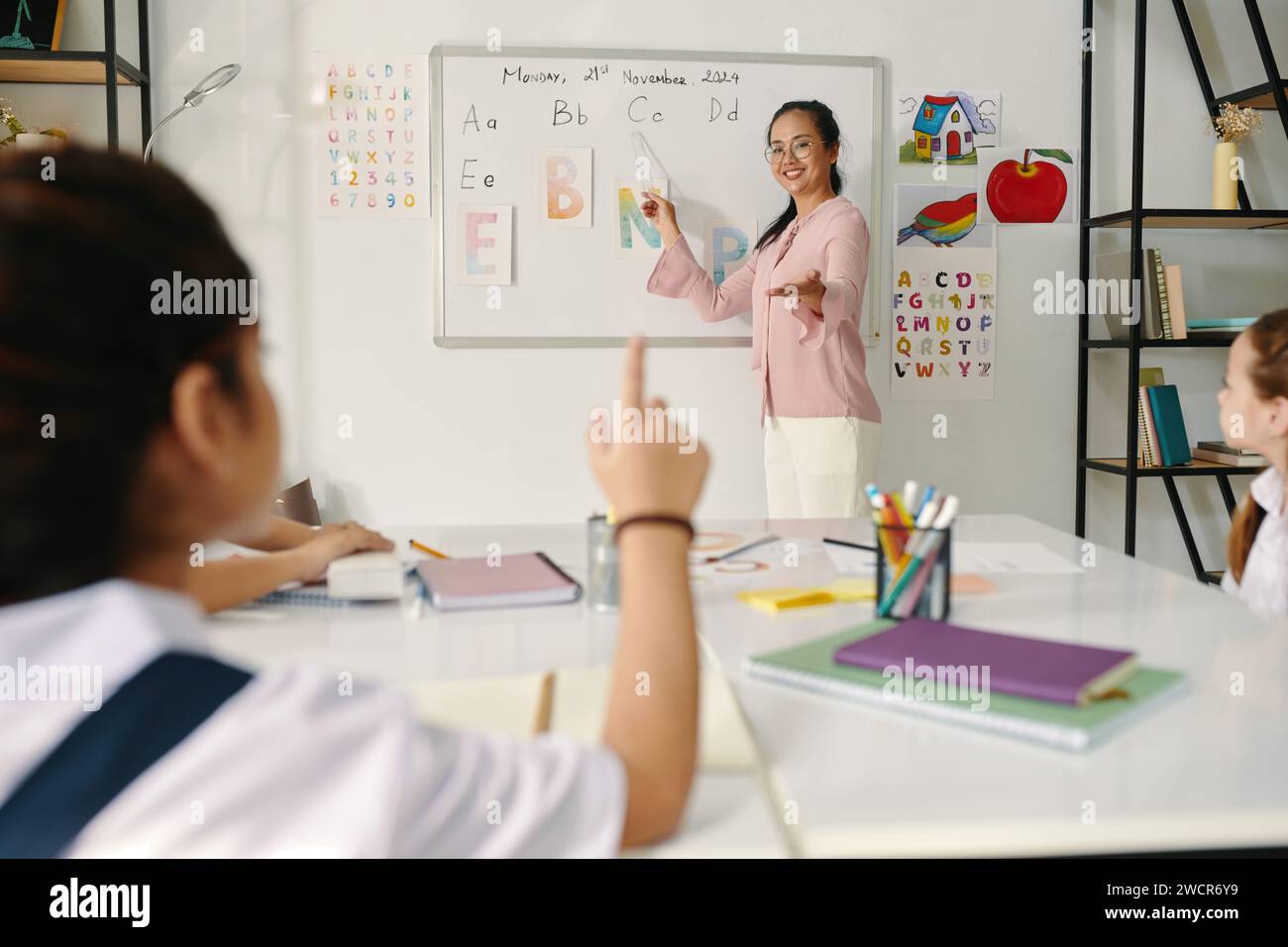 English teacher asking student to name letter on whiteboard Stock Photo ...