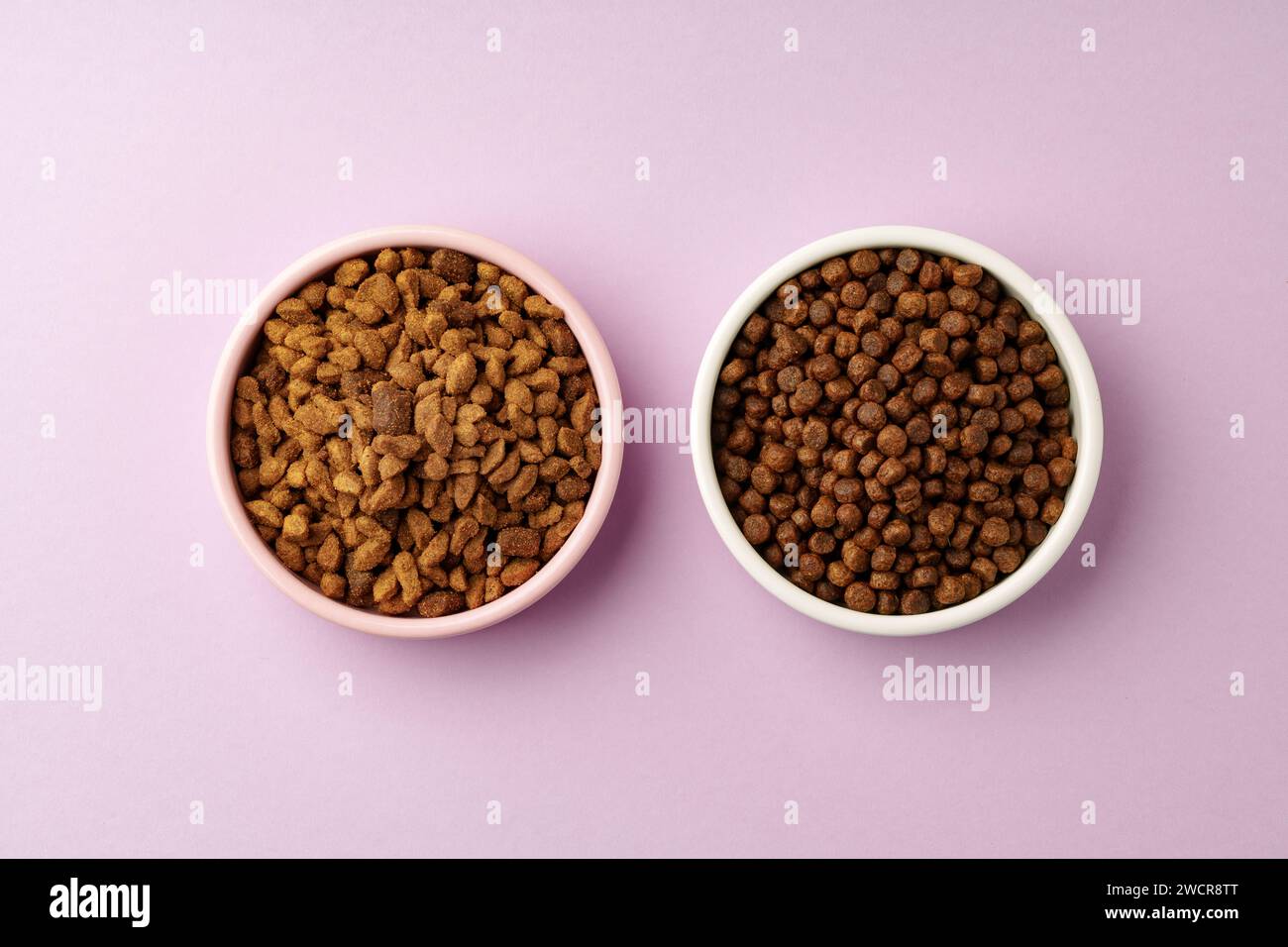 Cat food on pink background in studio Stock Photo - Alamy