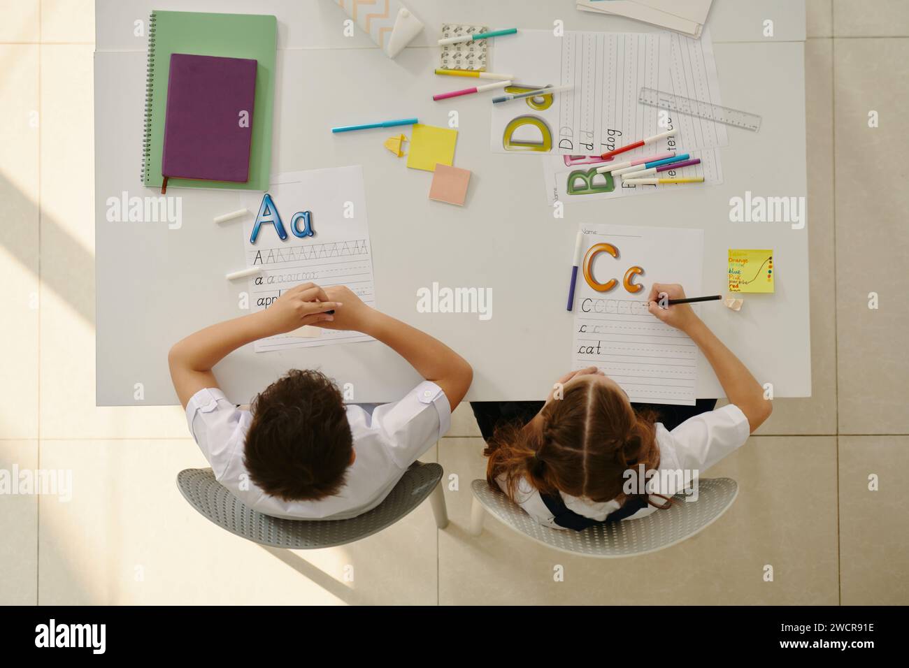 Kids learning writing letters of English language alphabet Stock Photo ...