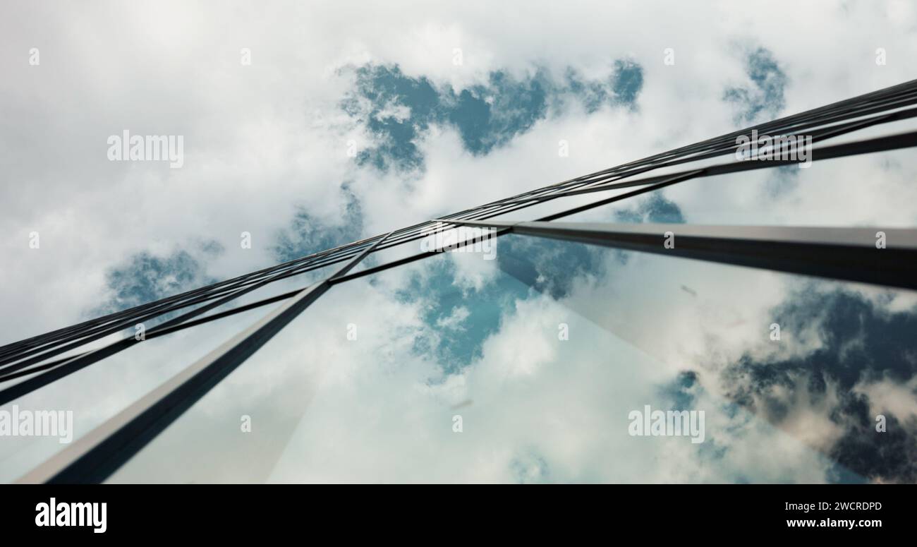 Low angle, skyscraper building and clouds in city with reflection ...