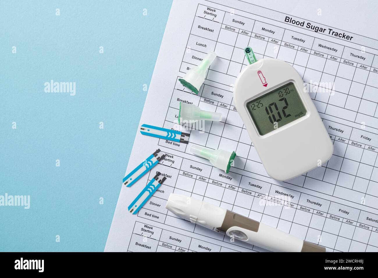 Top view of glucometer, lancet pen, strips and blood sugar tracker on ...