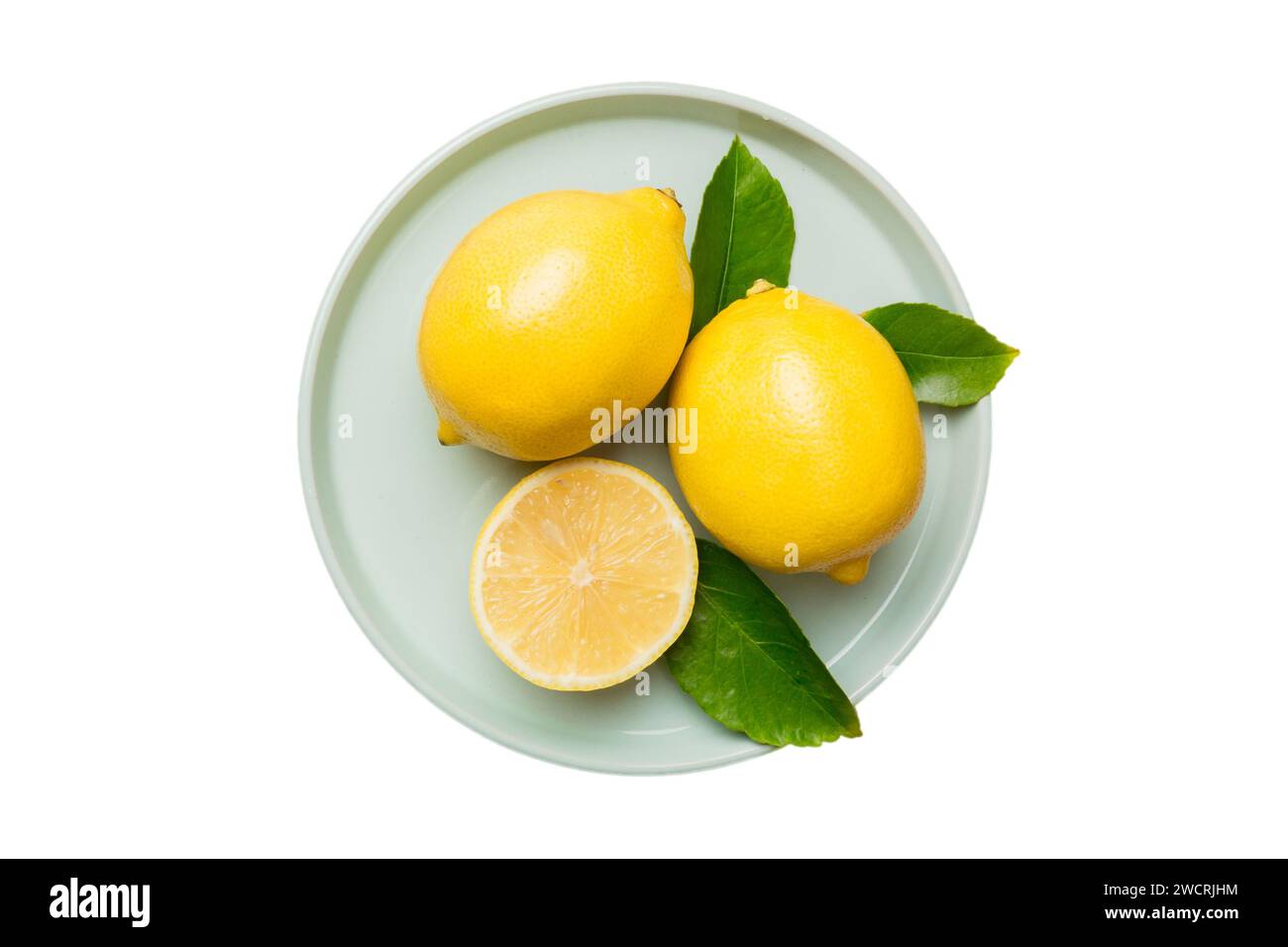 Fresh cutted lemon and whole lemons over round plate isolated on white ...