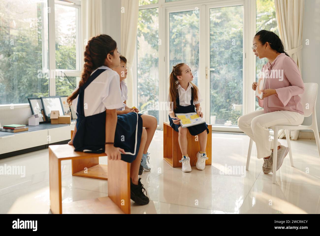 Group of kids repeating after teacher when reading letter on card Stock ...