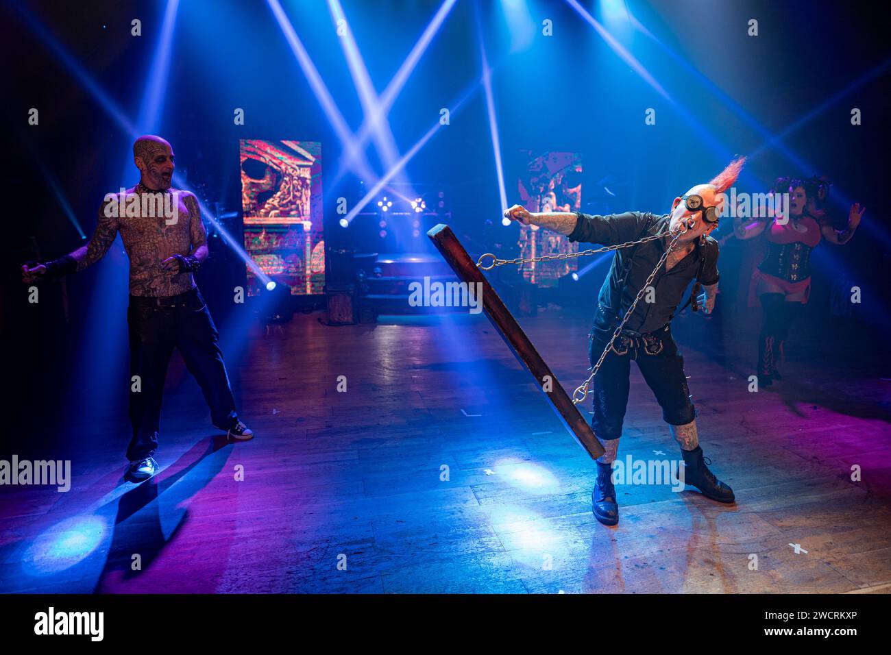 An artist known as Hannibal swings a wooden plank from chains attached ...