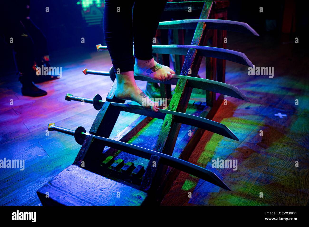 An artist walks up a ladder made from steel swords during full dress ...