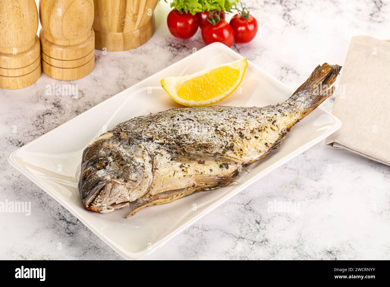 Baked Dorado fish served lemon slice Stock Photo - Alamy