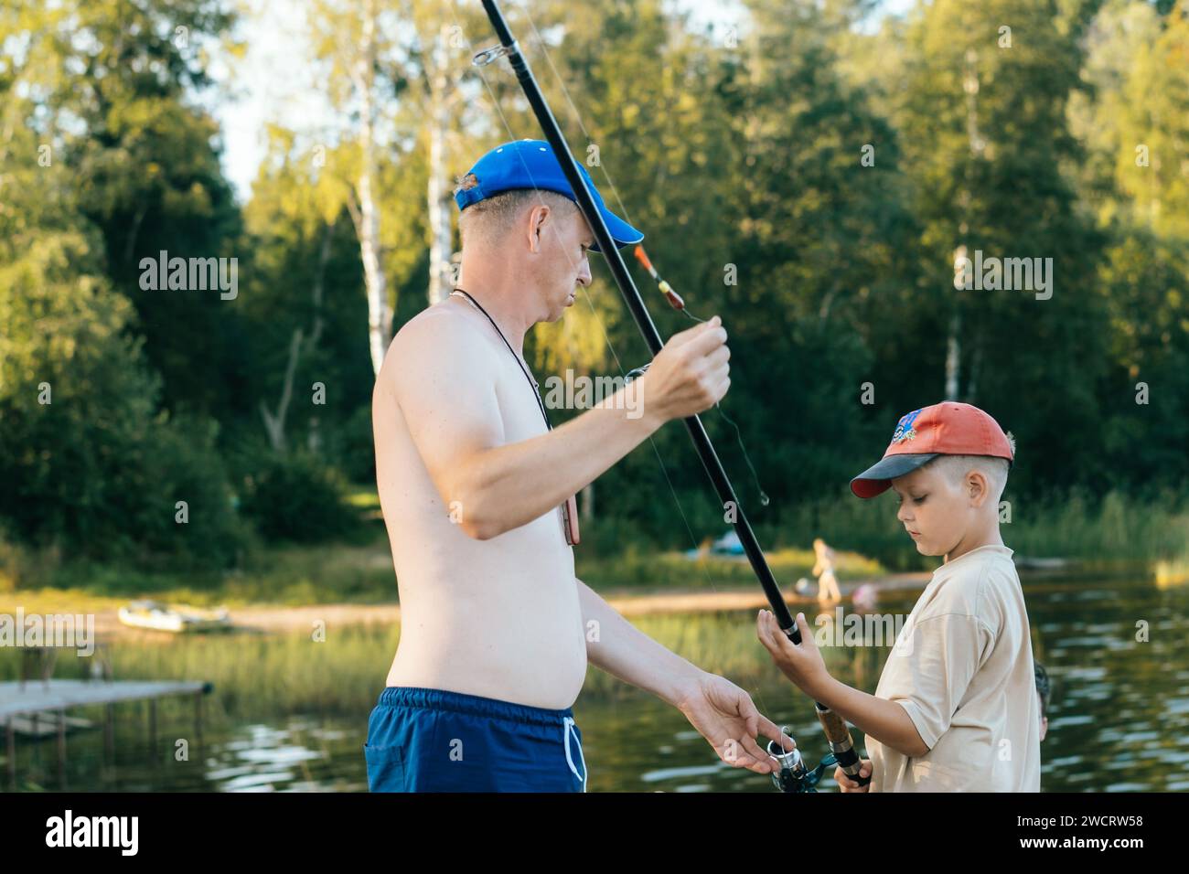 man teaching his little son how to do fishing using fishing pole Stock ...