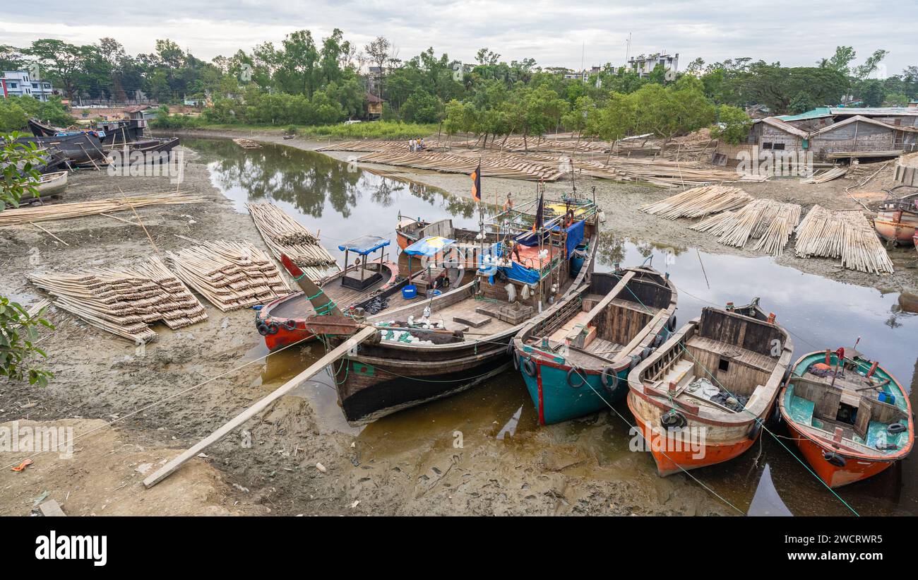 Scenic landscape view of boats and rafts of bamboo on river bank ...