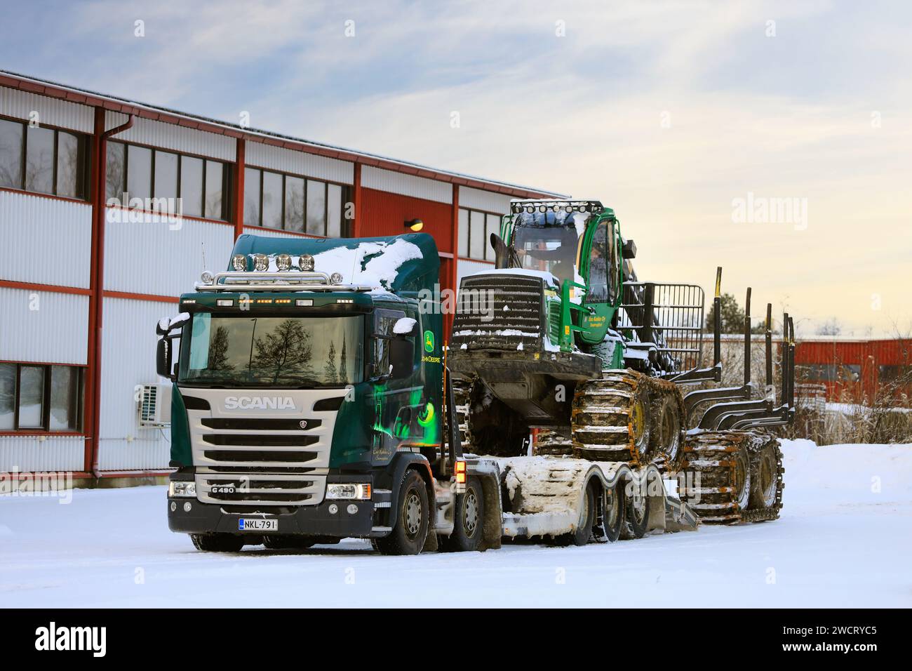 Loading John Deere 1210E forestry forwarder onto Scania G490 truck ...