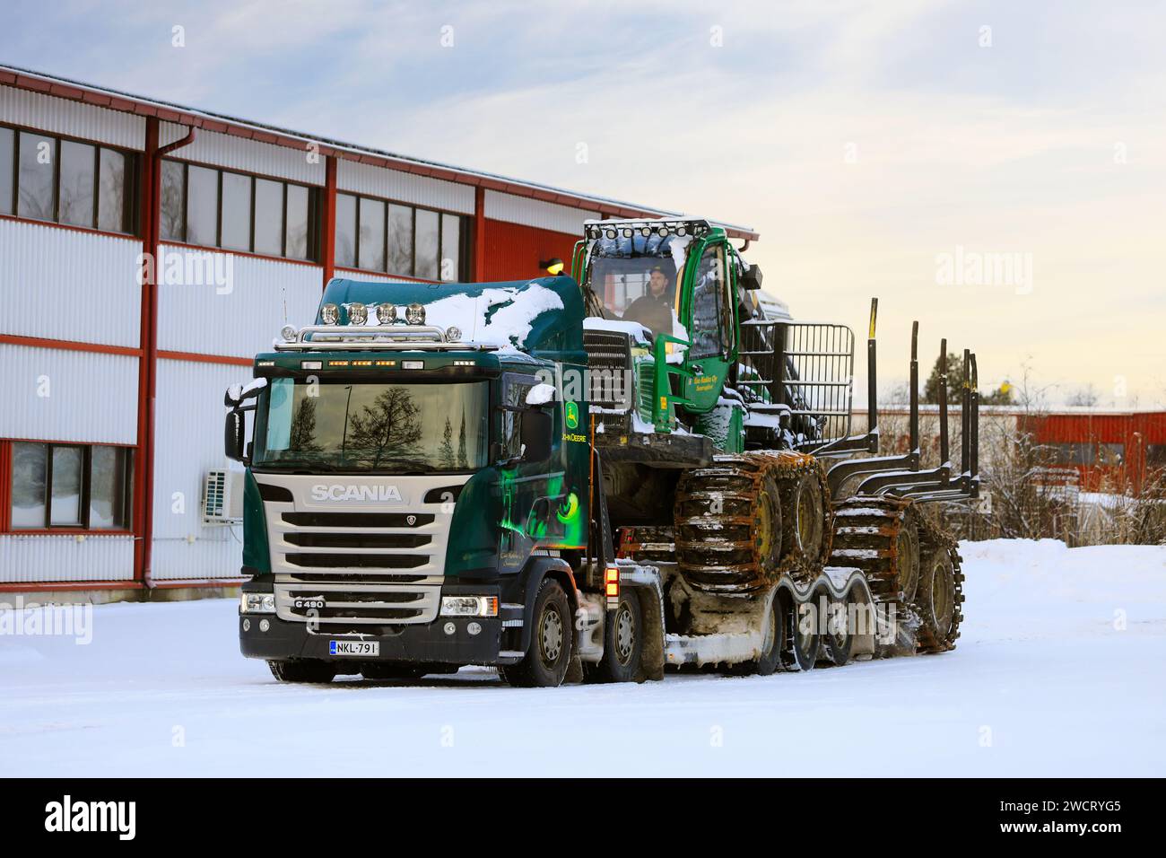 Loading John Deere 1210E forestry forwarder onto Scania G490 truck ...