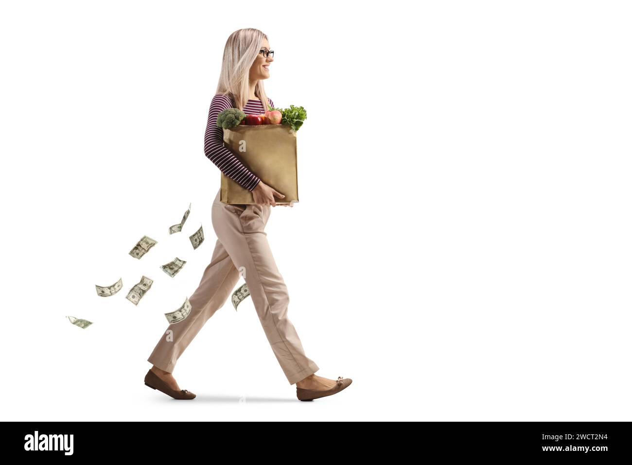 Full length profile shot of a woman walking with a grocery bag and ...