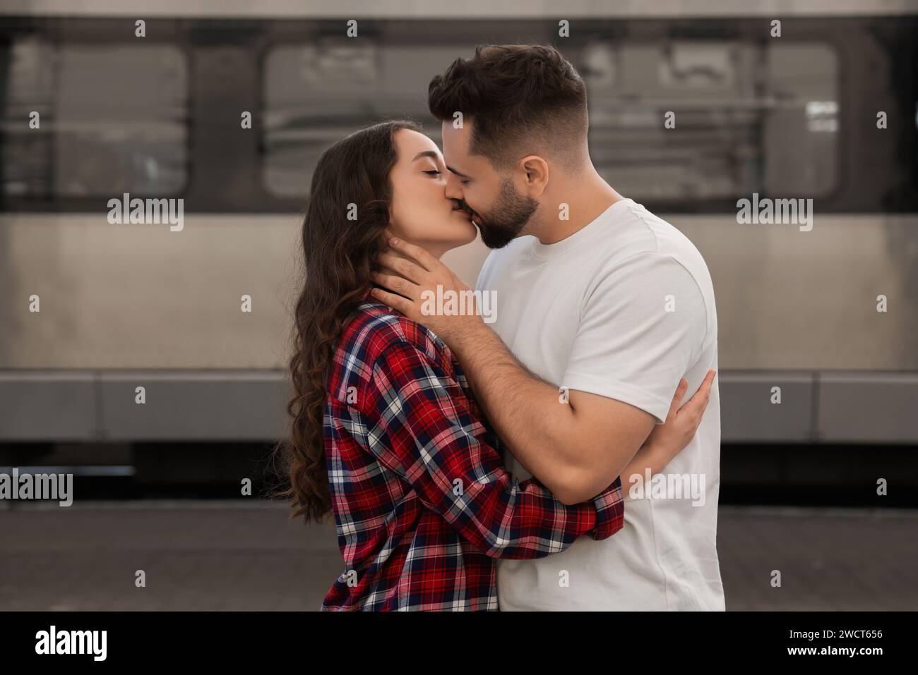 Long-distance relationship. Beautiful couple kissing on platform of railway station Stock Photo ...