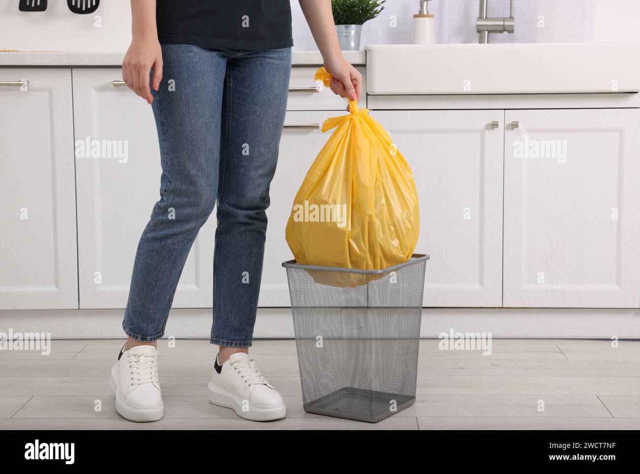 Woman taking garbage bag out of trash bin in kitchen, closeup Stock ...