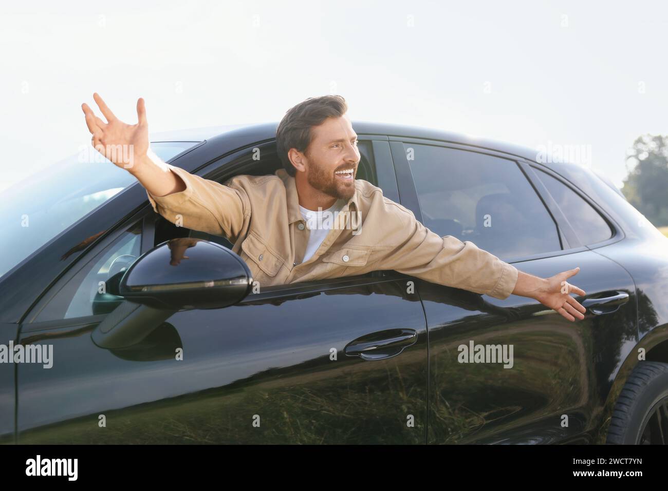 Enjoying trip. Happy man leaning out of car window outdoors Stock Photo ...