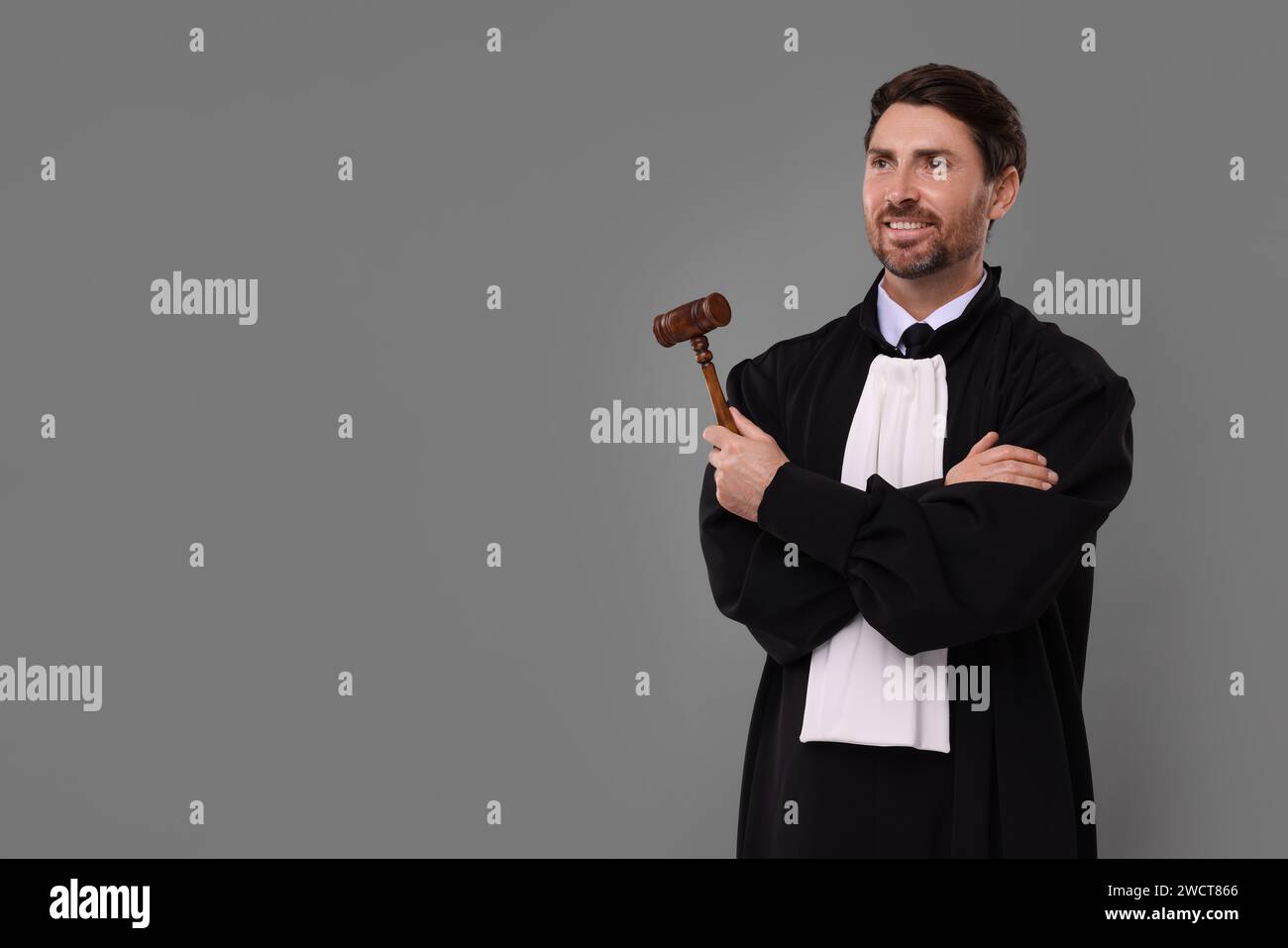 Happy judge with gavel on grey background. Space for text Stock Photo ...